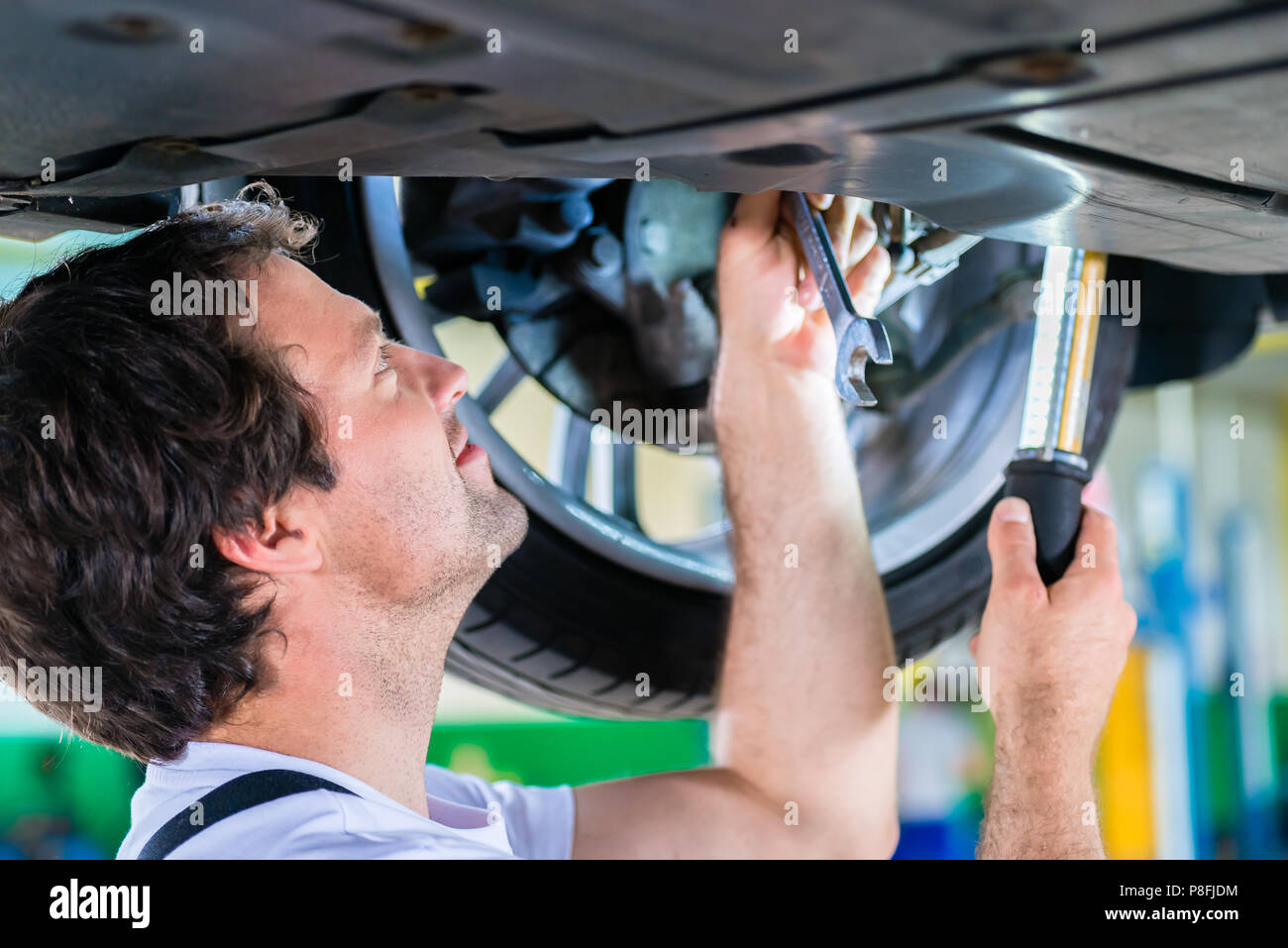 Mechanic working wheel in car service workshop Stock Photo - Alamy