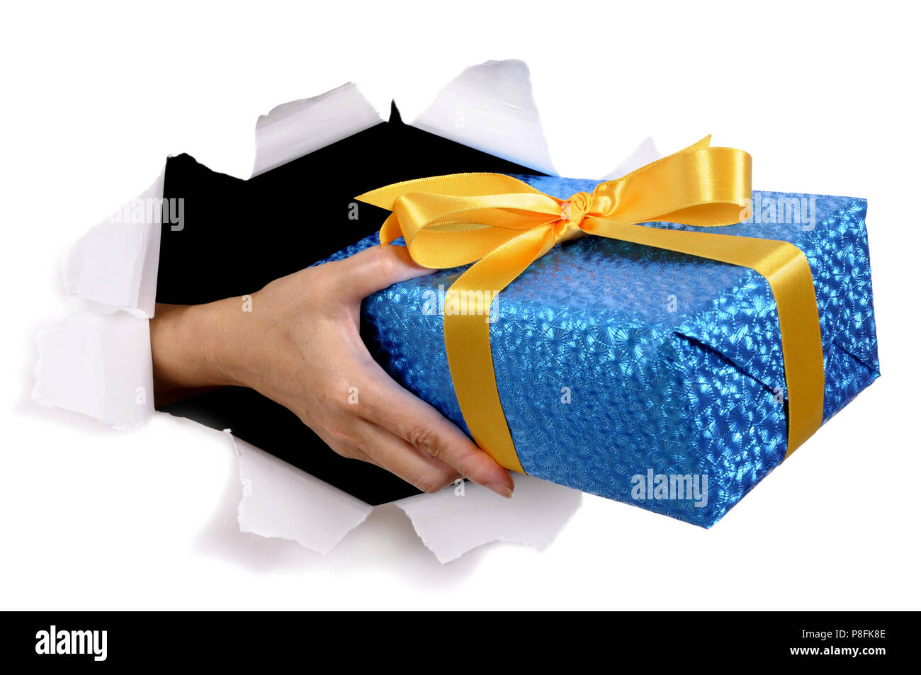 Man hand delivering or giving gift through torn white paper background ...