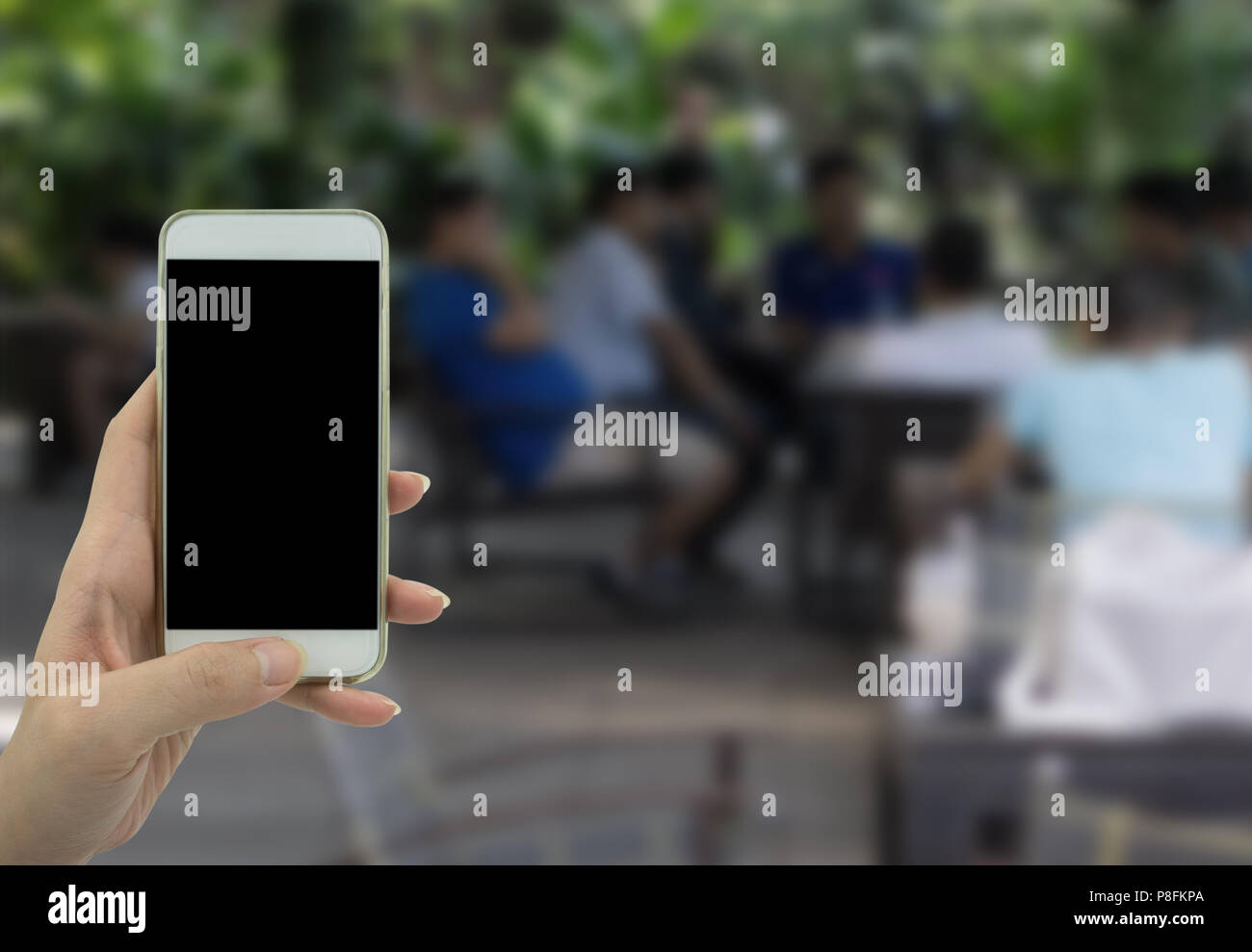 Woman hand shows mobile smartphone in vertical position, blurred ...