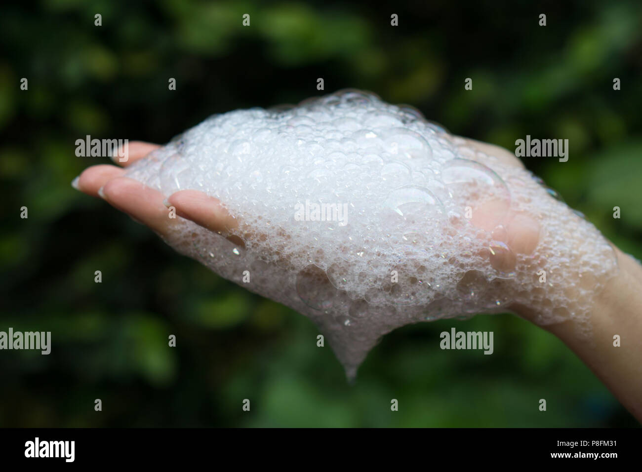 Bubbles in the hands of women and green background Stock Photo - Alamy
