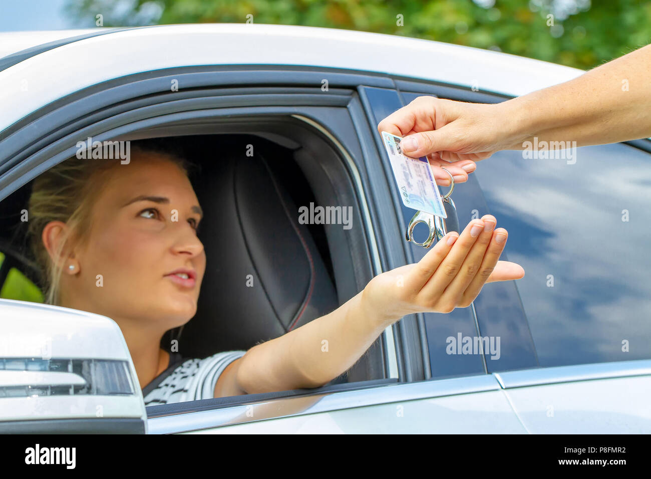 Young woman getting in her new car Stock Photo - Alamy