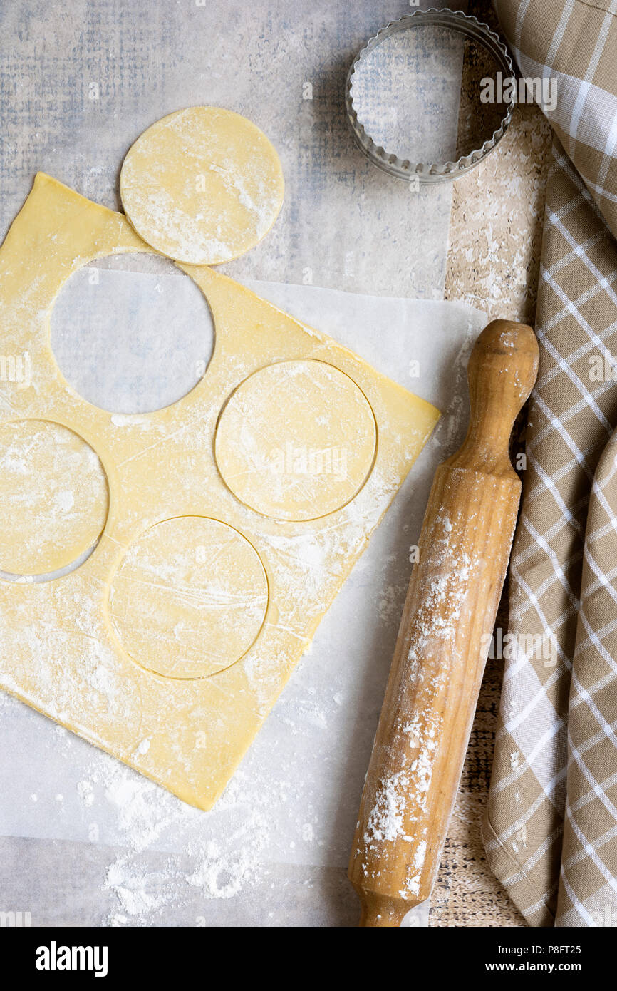 Round circles of shortcrust pastry with a rolling pin and pastry cutter ...