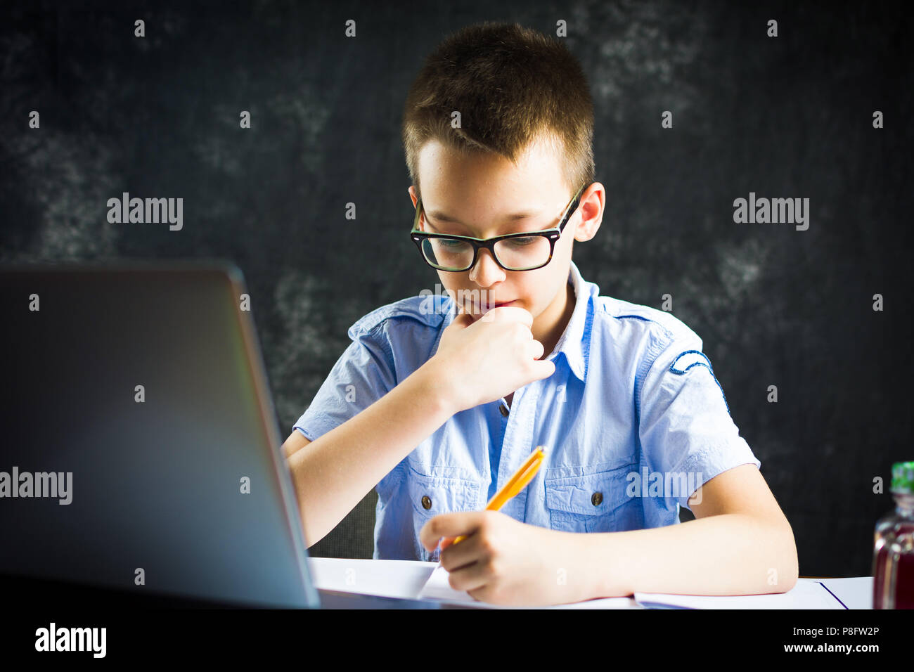 Schoolboy studying and working on homework at home Stock Photo - Alamy