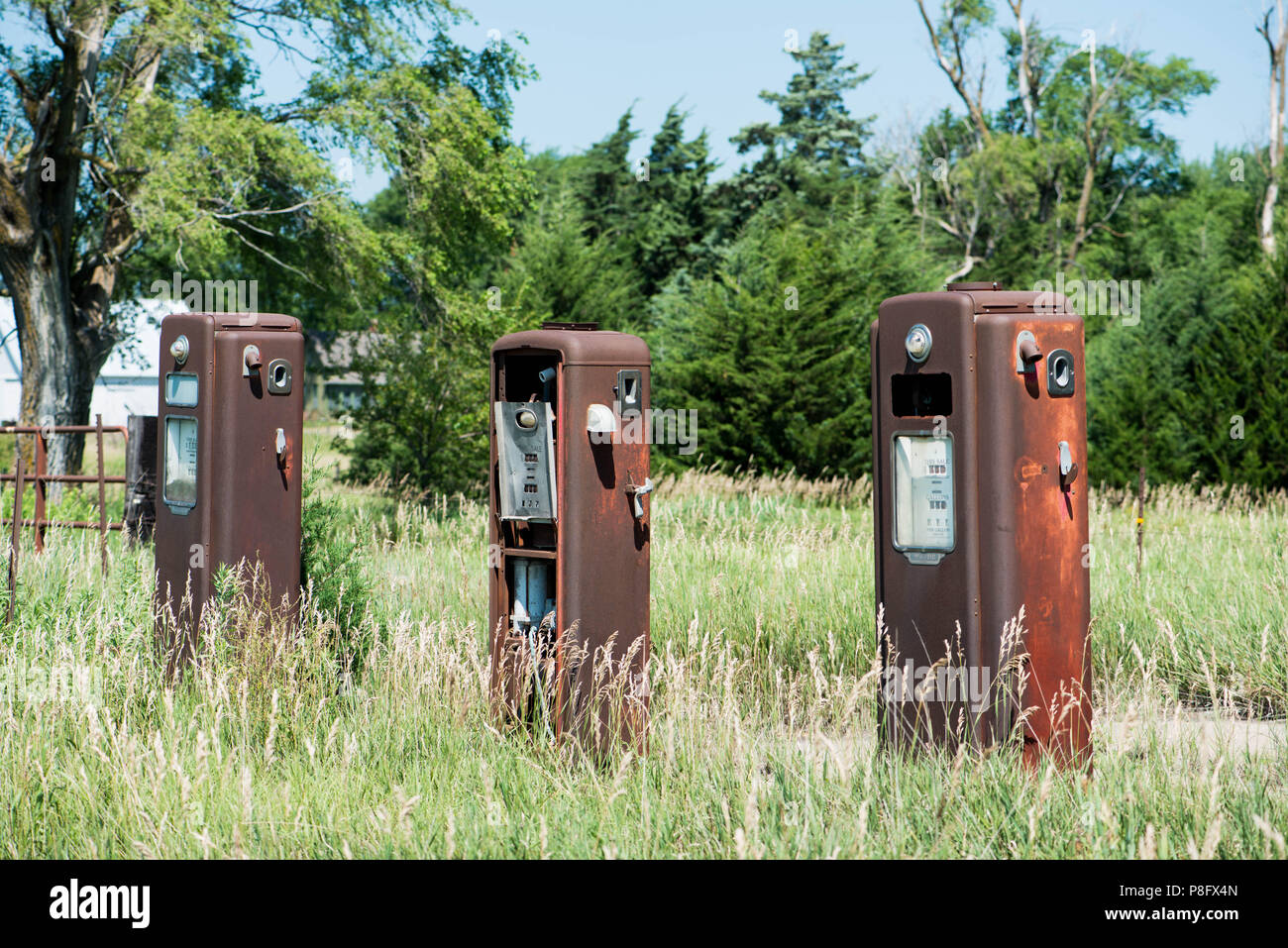 Three rusty old abandoned gas pumps at a roadside service station Stock ...