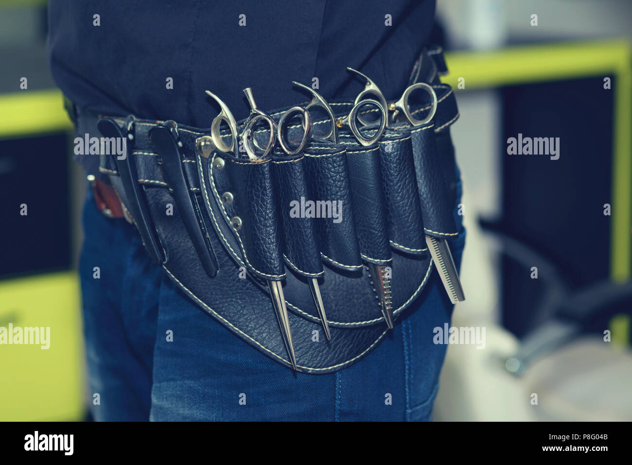 Leather belt with scissors on a waist of a hairdresser. Selective focus ...