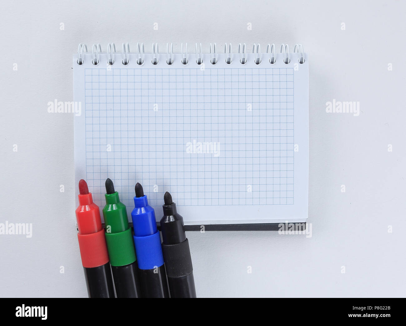 multicolored markers and open Notepad isolated on white background ...