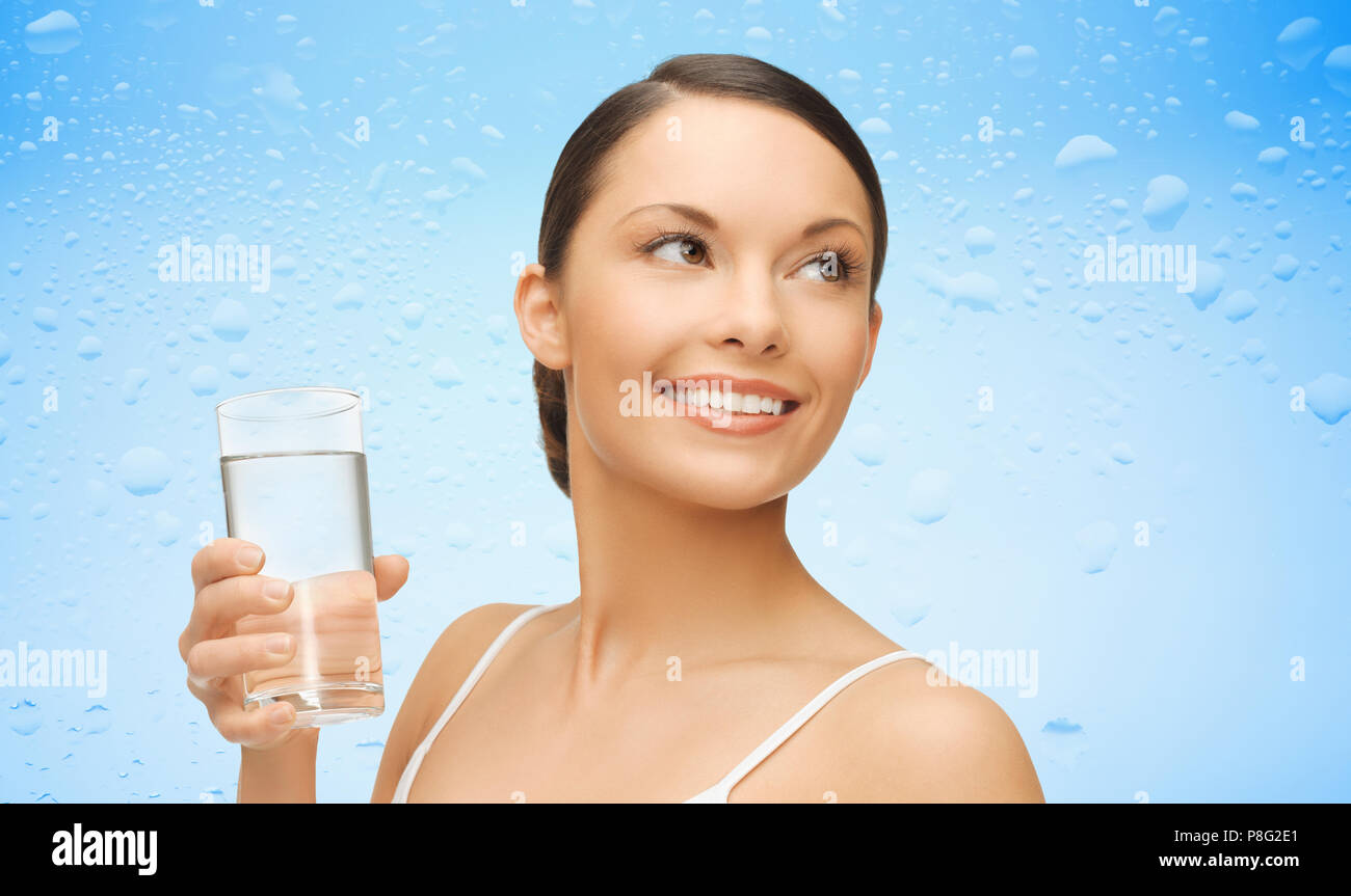woman with glass of water over wet blue background Stock Photo - Alamy