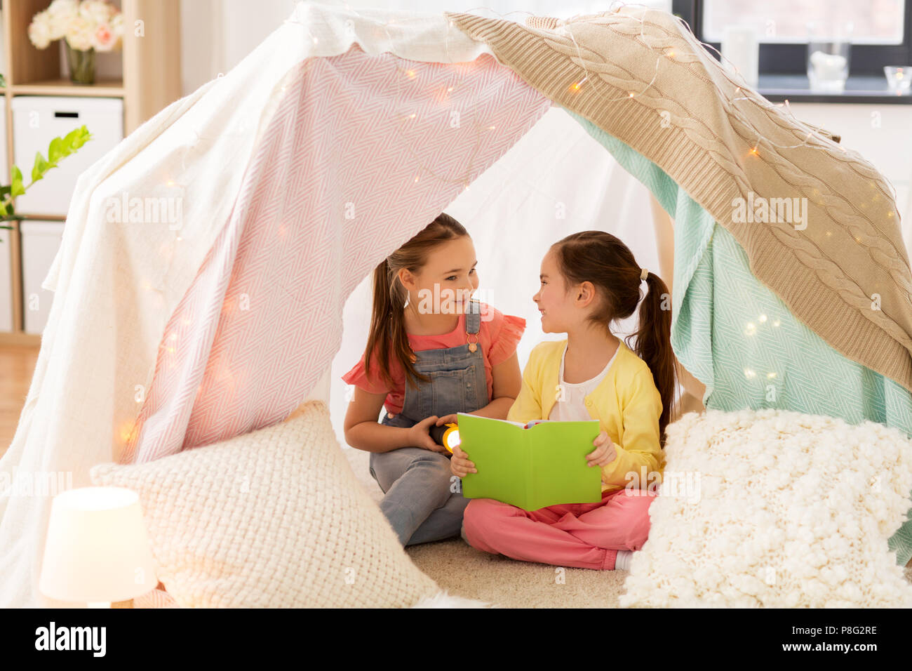 little girls reading book in kids tent at home Stock Photo - Alamy
