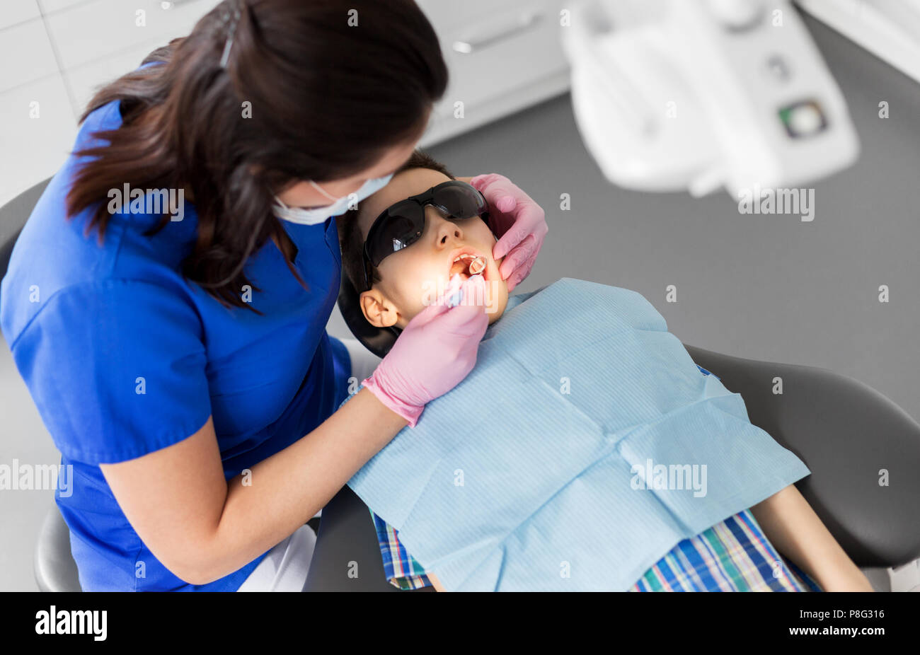 dentist checking for kid teeth at dental clinic Stock Photo - Alamy