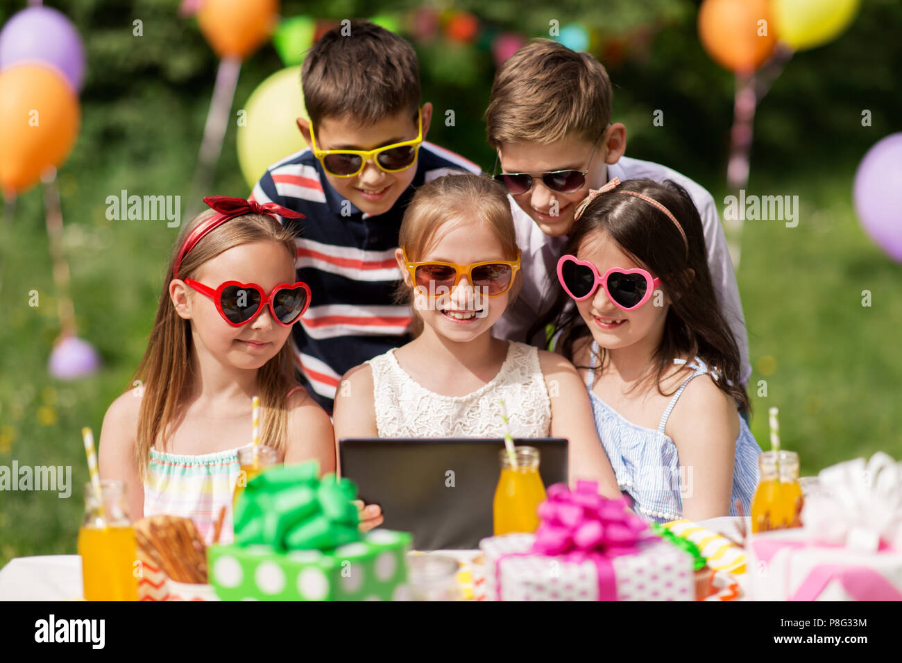 happy kids with tablet pc on birthday party Stock Photo - Alamy