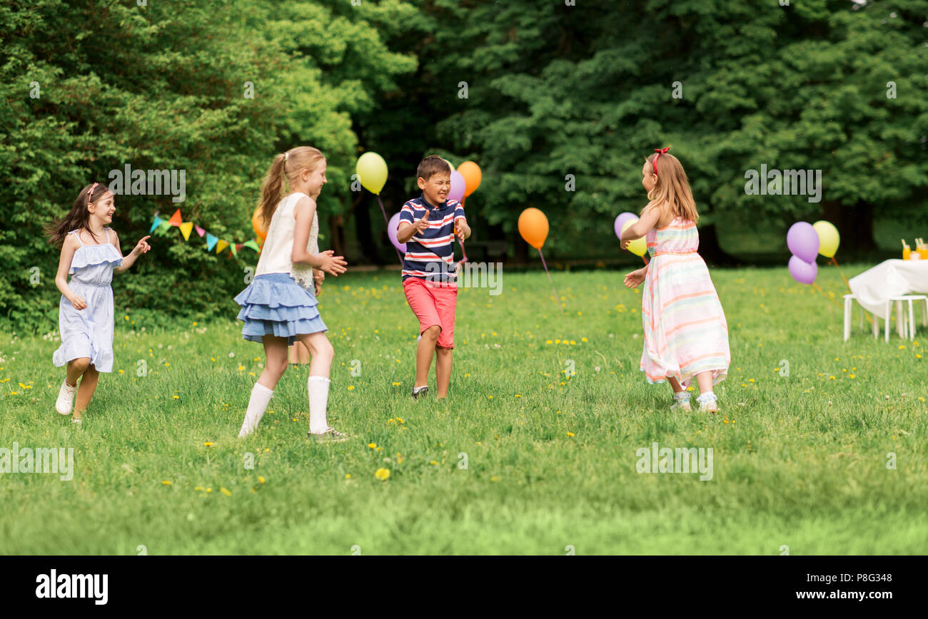 happy kids playing tag game at birthday party Stock Photo - Alamy