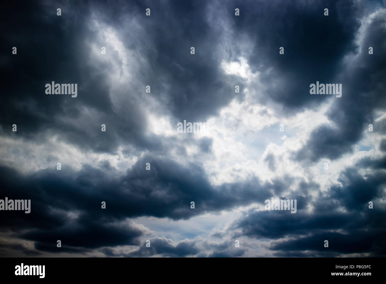 Dramatic rain clouds with a blue sky gap Stock Photo - Alamy