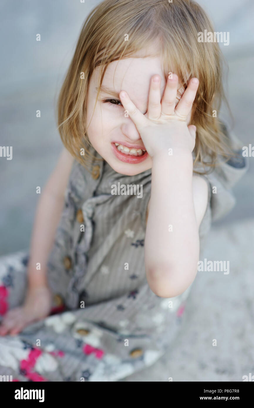 Adorable little girl covering her face Stock Photo - Alamy