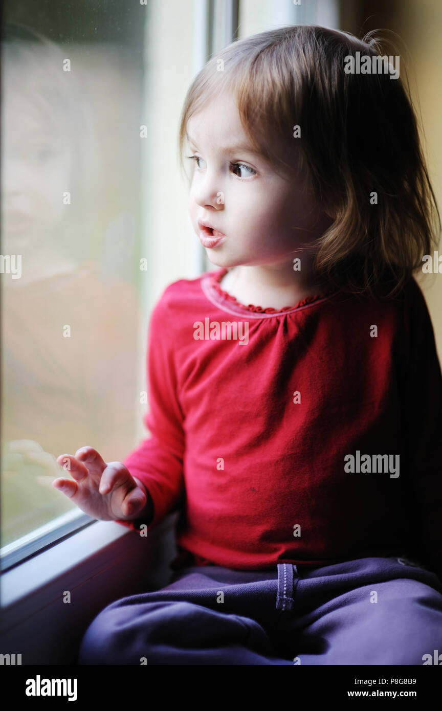 Adorable smiling little girl by the window Stock Photo - Alamy