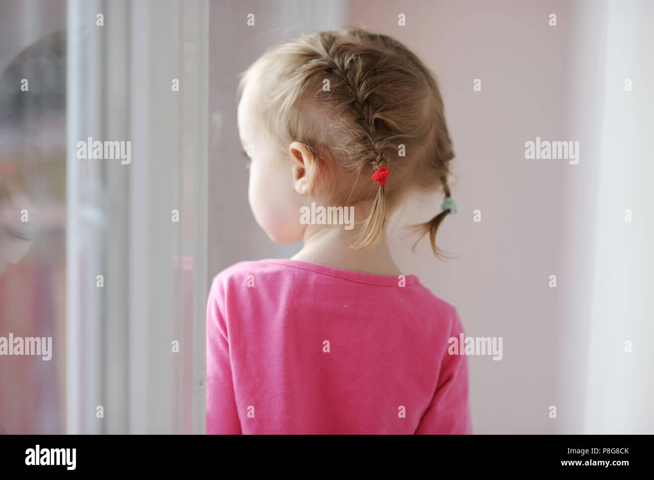 Adorable smiling little girl by the window Stock Photo - Alamy