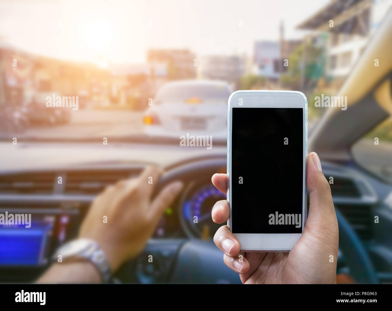 Man using a smartphone while driving a car - Sunset filter effect Stock ...
