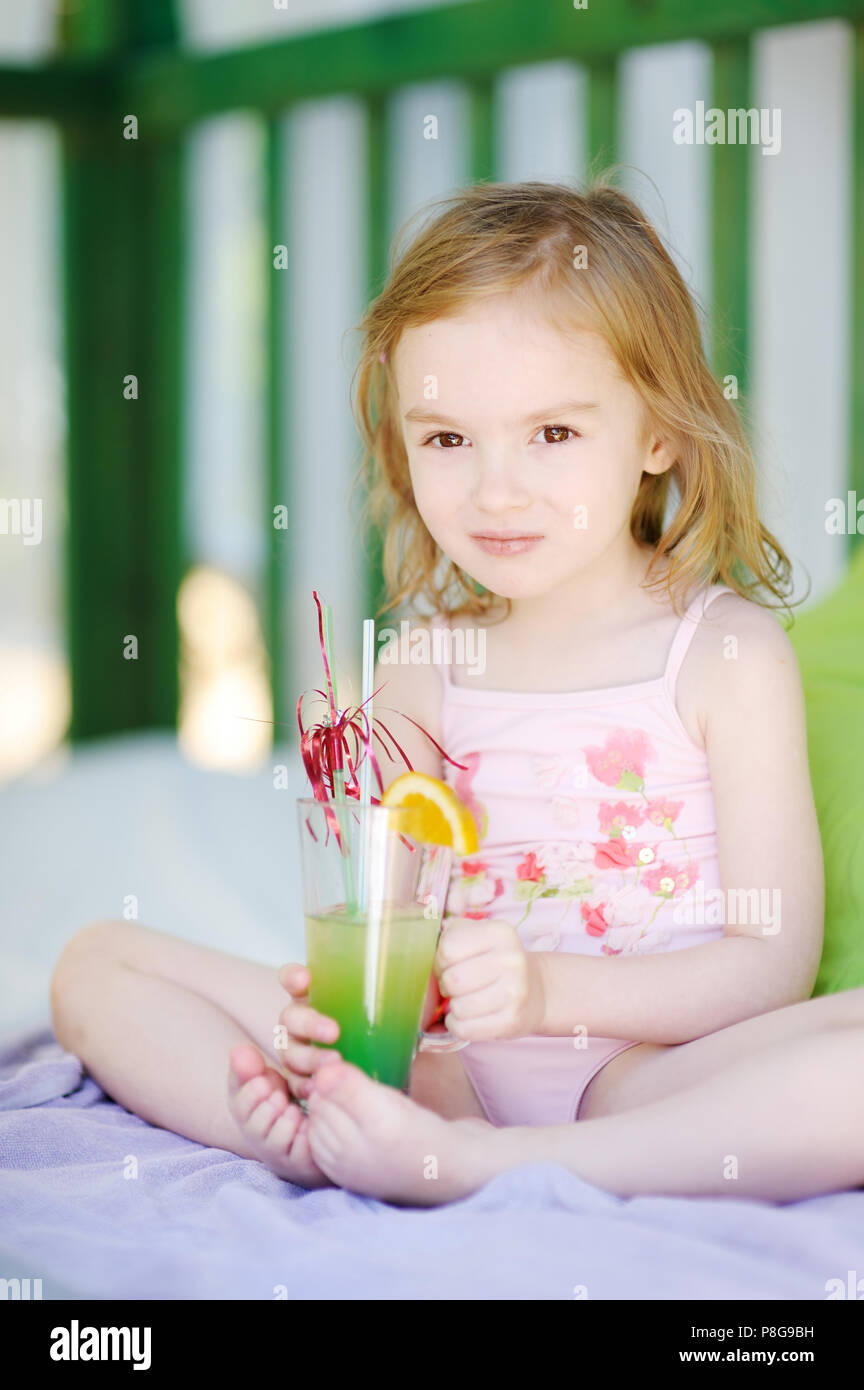 Cute little girl in swimsuit drinking cocktail Stock Photo - Alamy