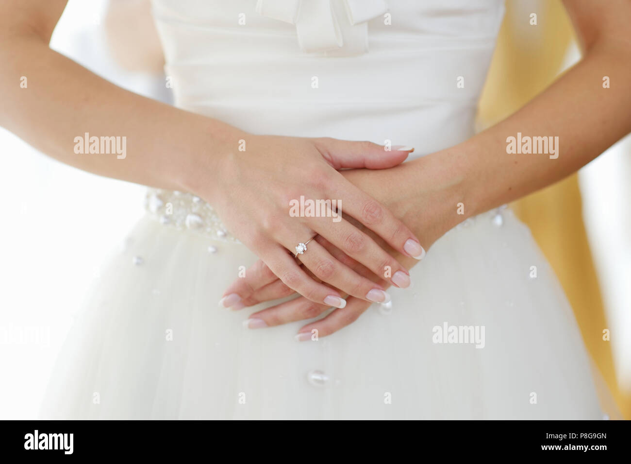 Bride's hands while putting wedding dress on Stock Photo - Alamy