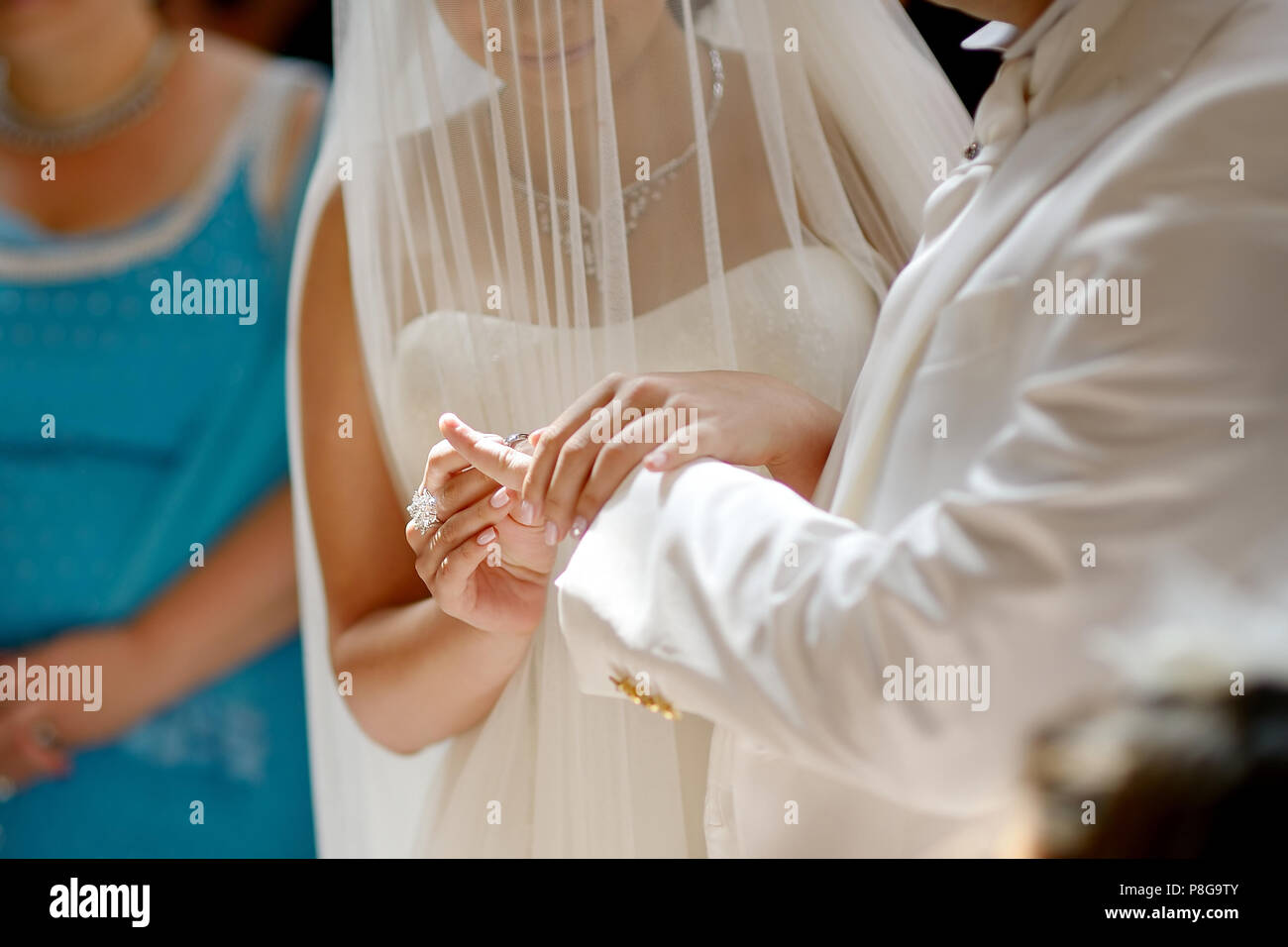 Bride is putting the ring on groom's finger Stock Photo - Alamy