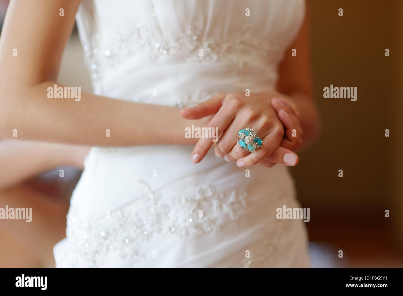 Bride's hands while putting wedding dress on Stock Photo - Alamy