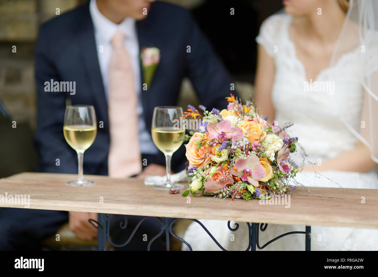 Wedding bouquet on a table, bride and groom on a background Stock Photo ...