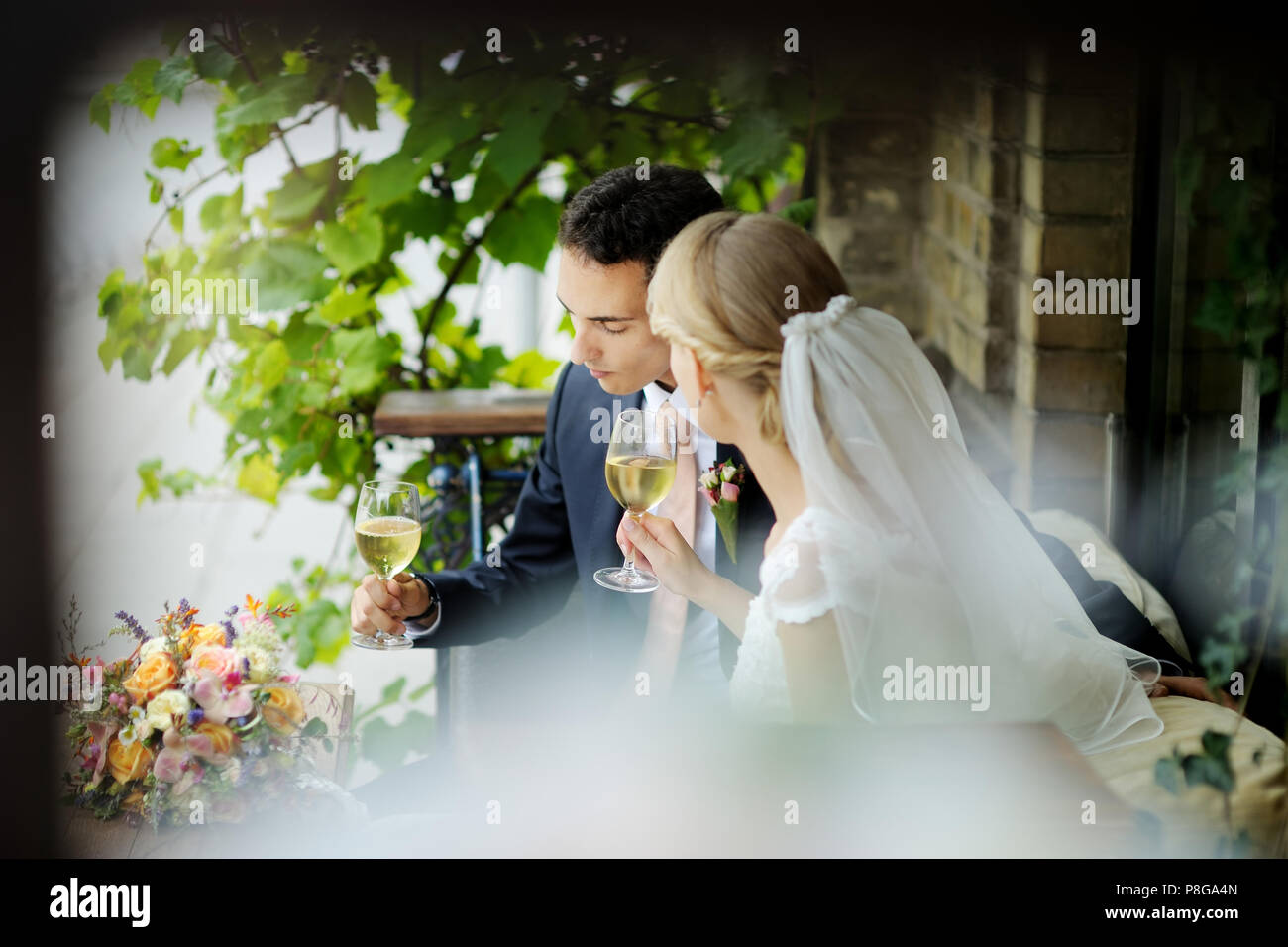Bride and groom drinking wine at an outdoor cafe Stock Photo - Alamy