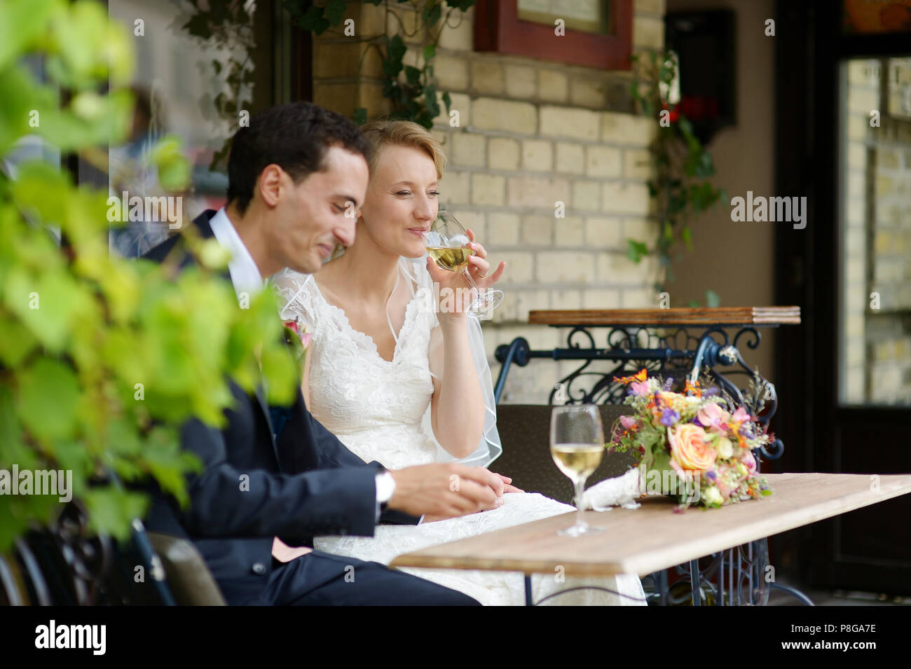 Bride and groom drinking wine at an outdoor cafe Stock Photo - Alamy