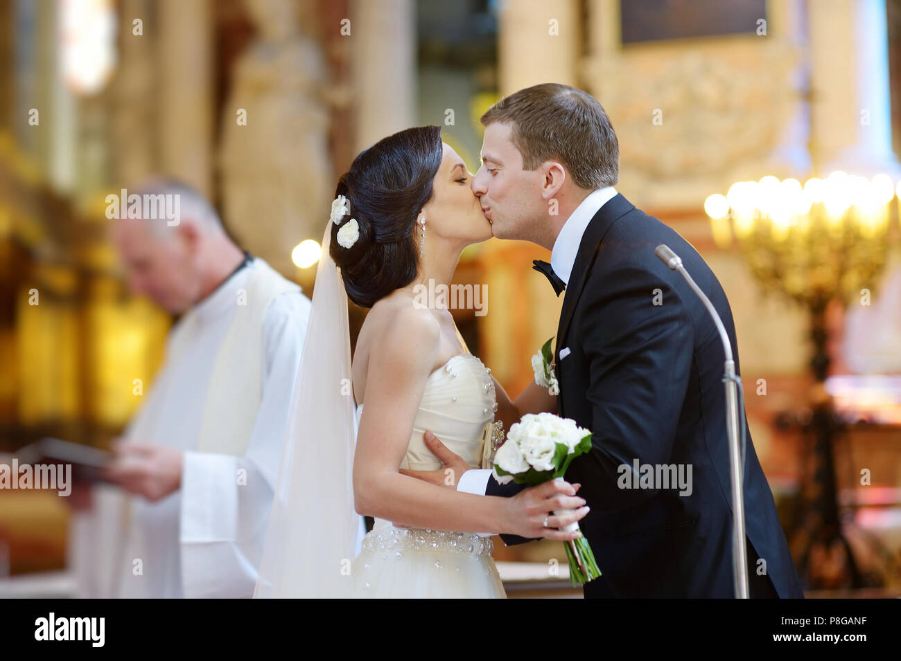 Bride and groom kissing in a church after wedding ceremony Stock Photo ...