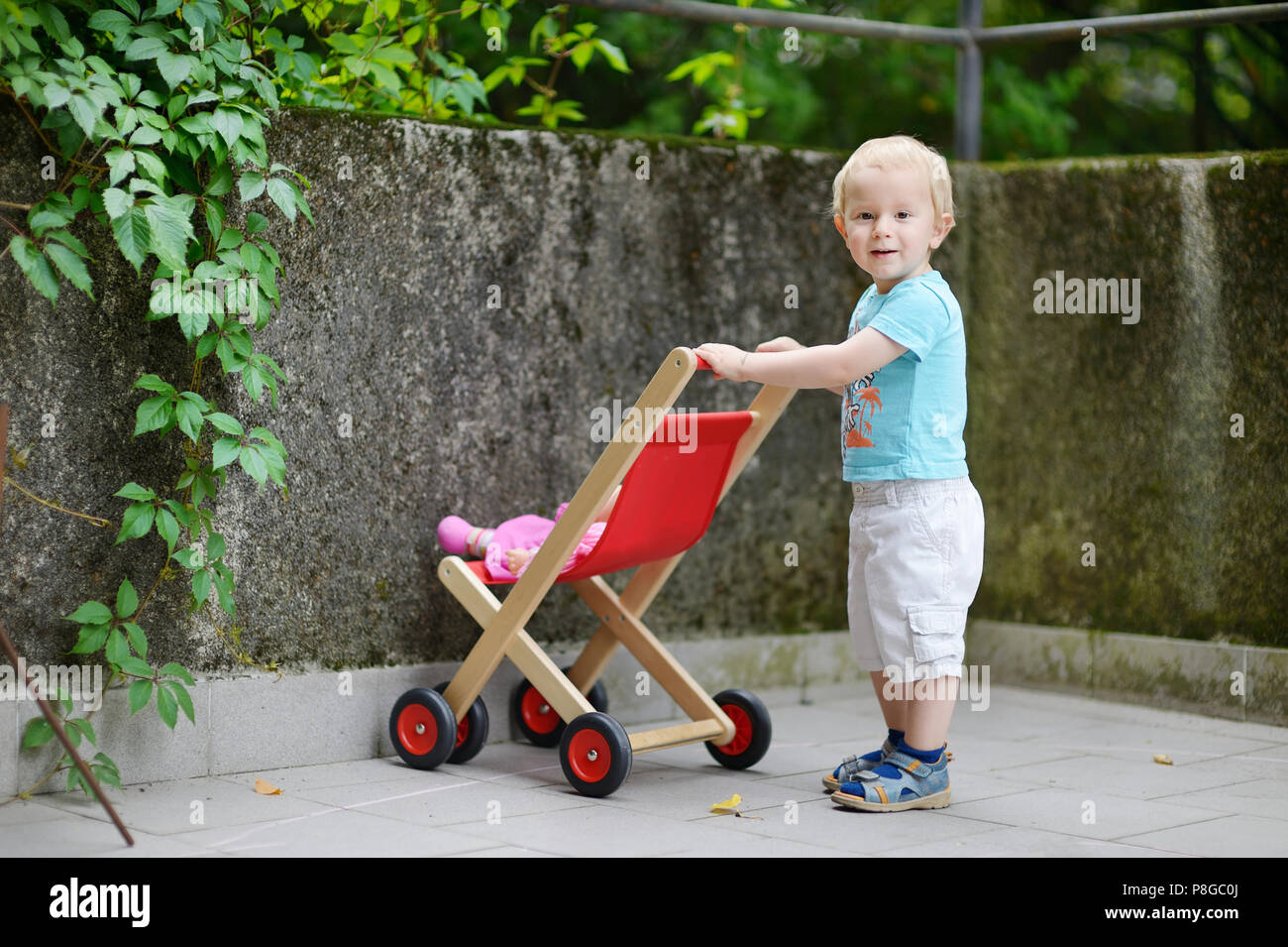 Cute little boy with his toy baby carriage Stock Photo - Alamy