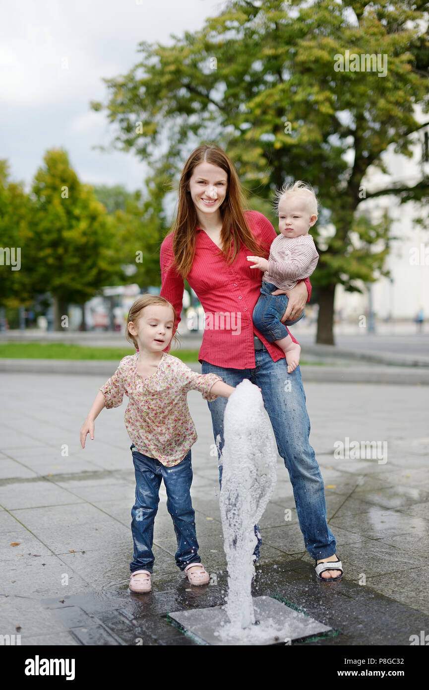 Happy family girl having fun by a city fountain Stock Photo - Alamy