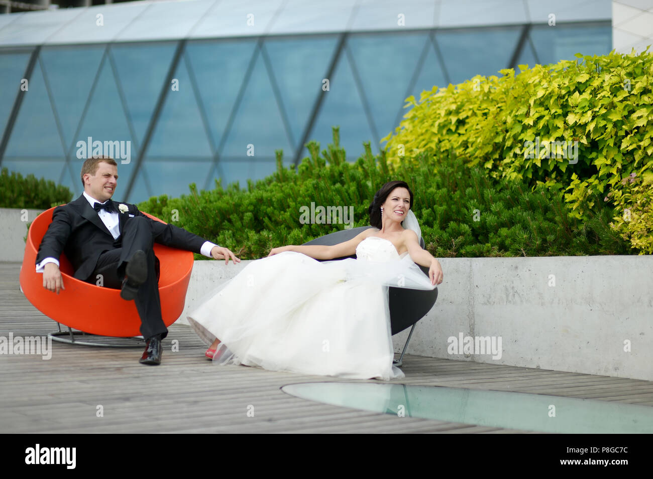 Happy bride and groom sitting in fancy chairs Stock Photo - Alamy