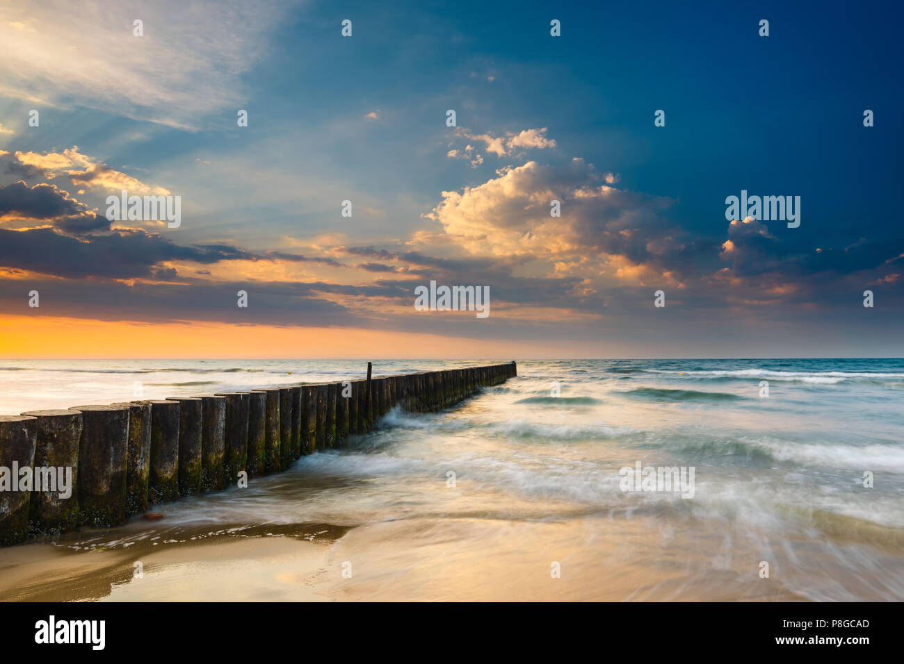 Sunset on the beach with breakwater, long time exposure Stock Photo - Alamy