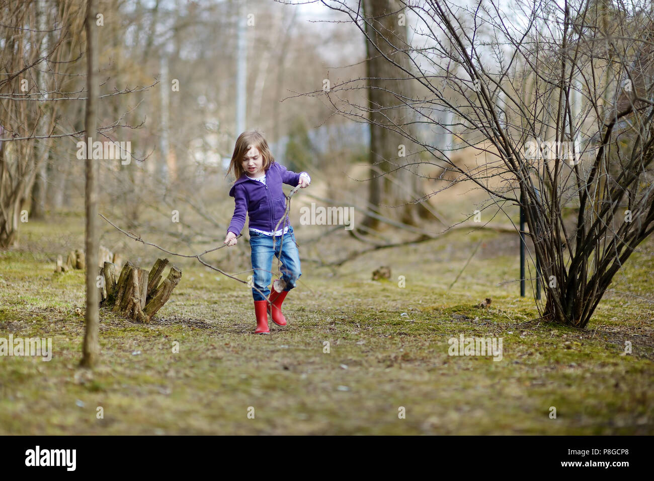 Adorable little girl having fun in a park at early spring Stock Photo ...