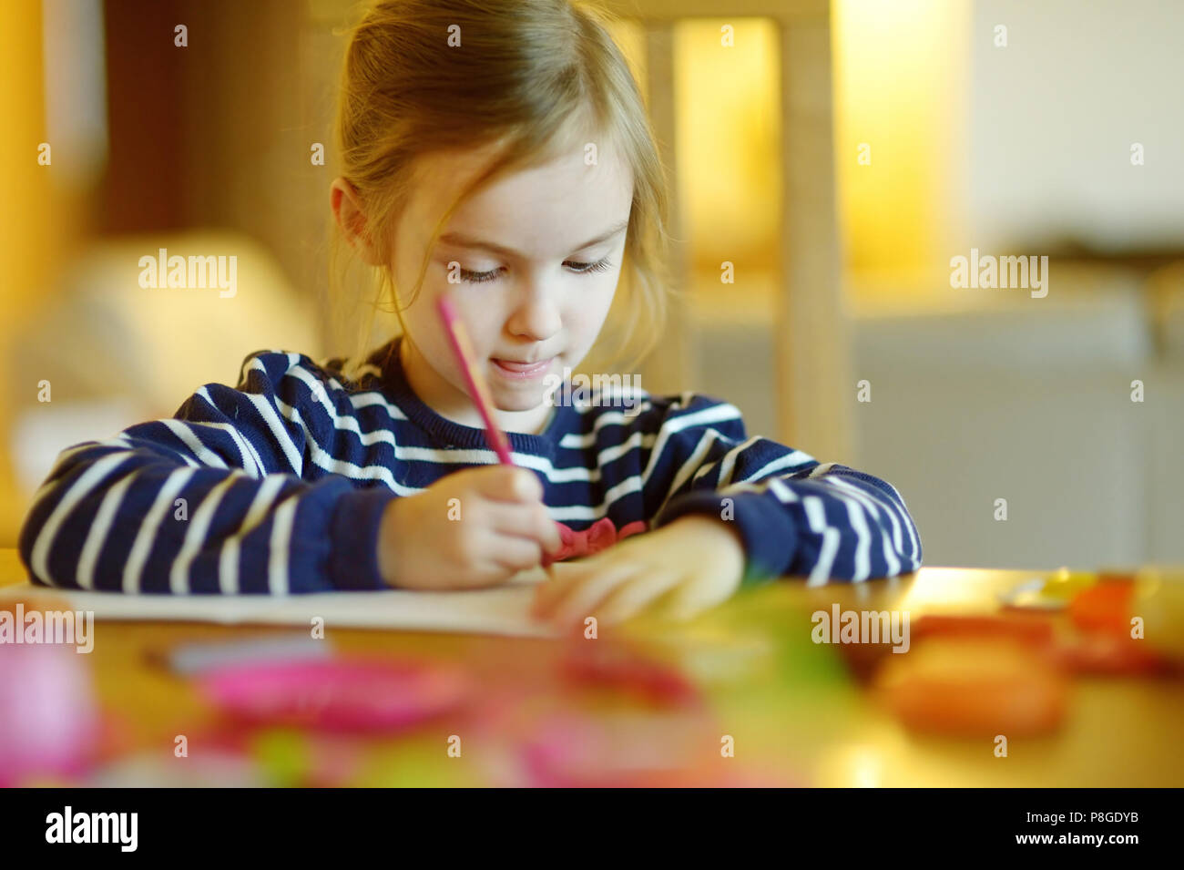 Cute little girl is drawing with pencils in preschool Stock Photo - Alamy