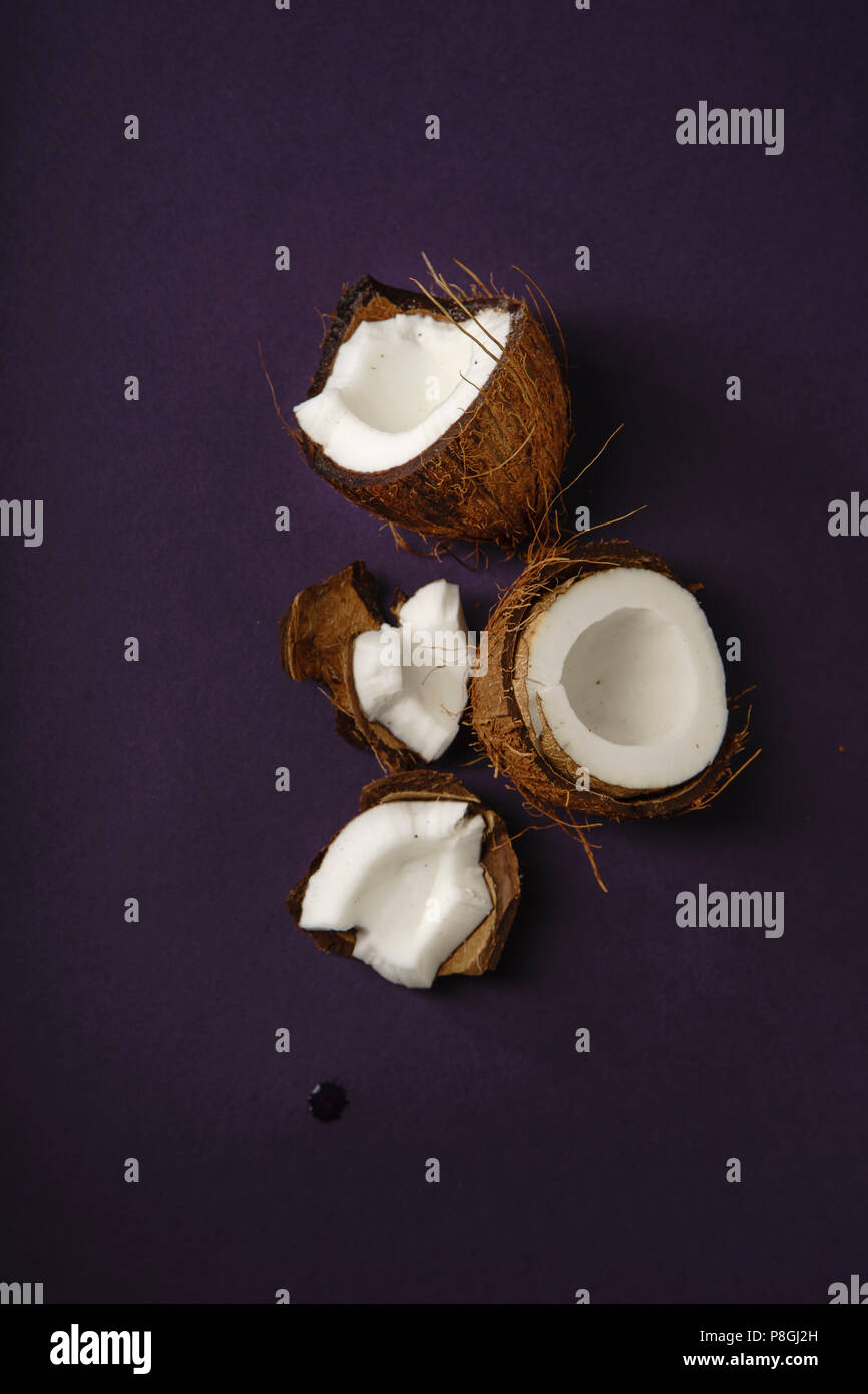 Cracked coconut arranged on dark purple background Stock Photo - Alamy