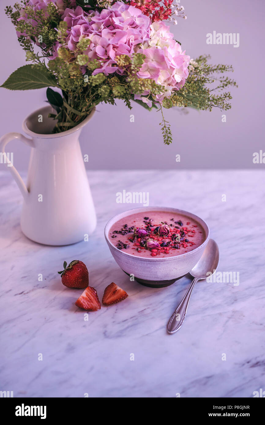 Strawberry smoothie bowl topped with cacao nibs, raspberry powder and ...