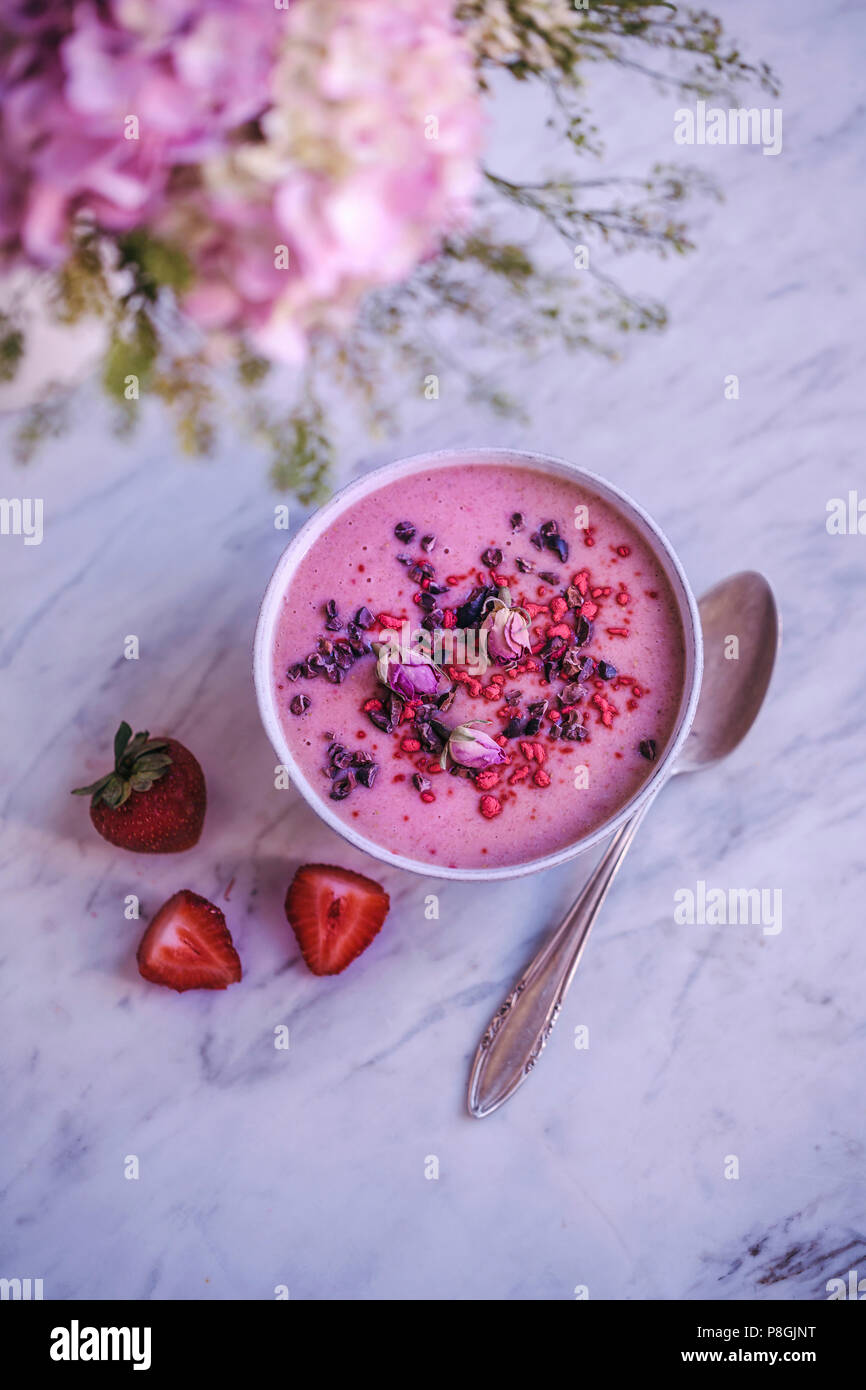 Strawberry smoothie bowl topped with cacao nibs, raspberry powder and ...