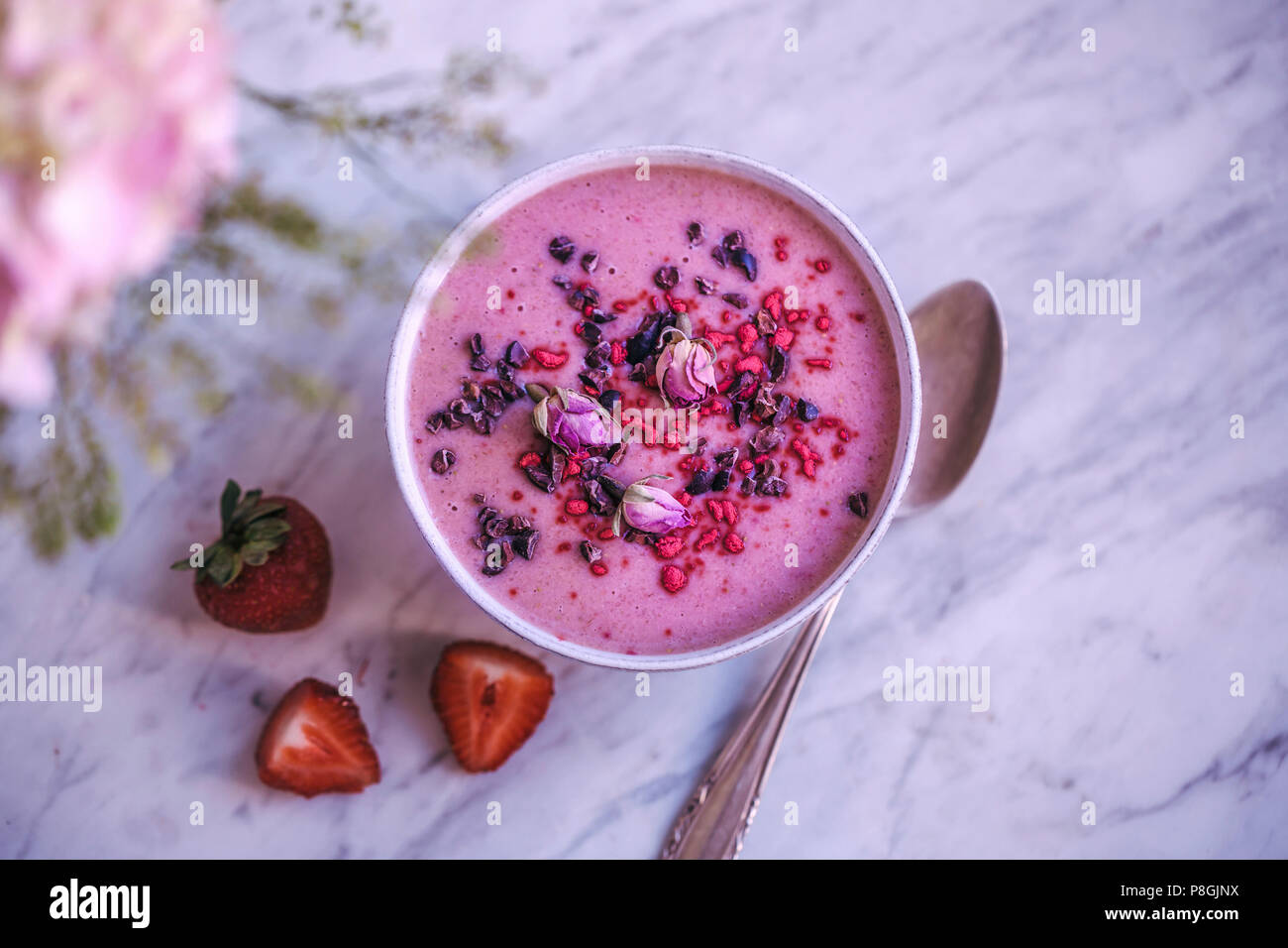 Strawberry smoothie bowl topped with cacao nibs, raspberry powder and ...