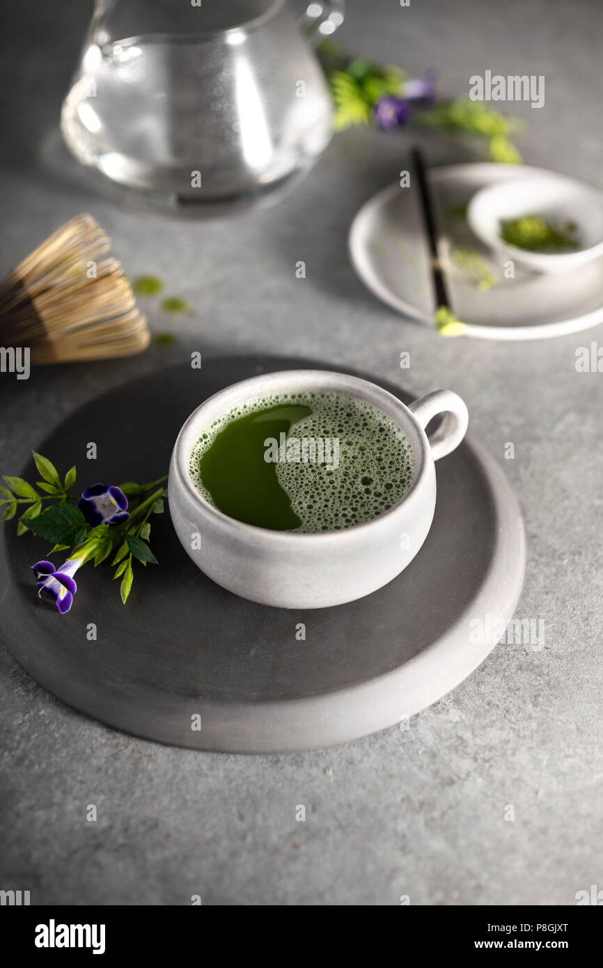 A warm cup of matcha green tea that has just been prepared with wooden ...