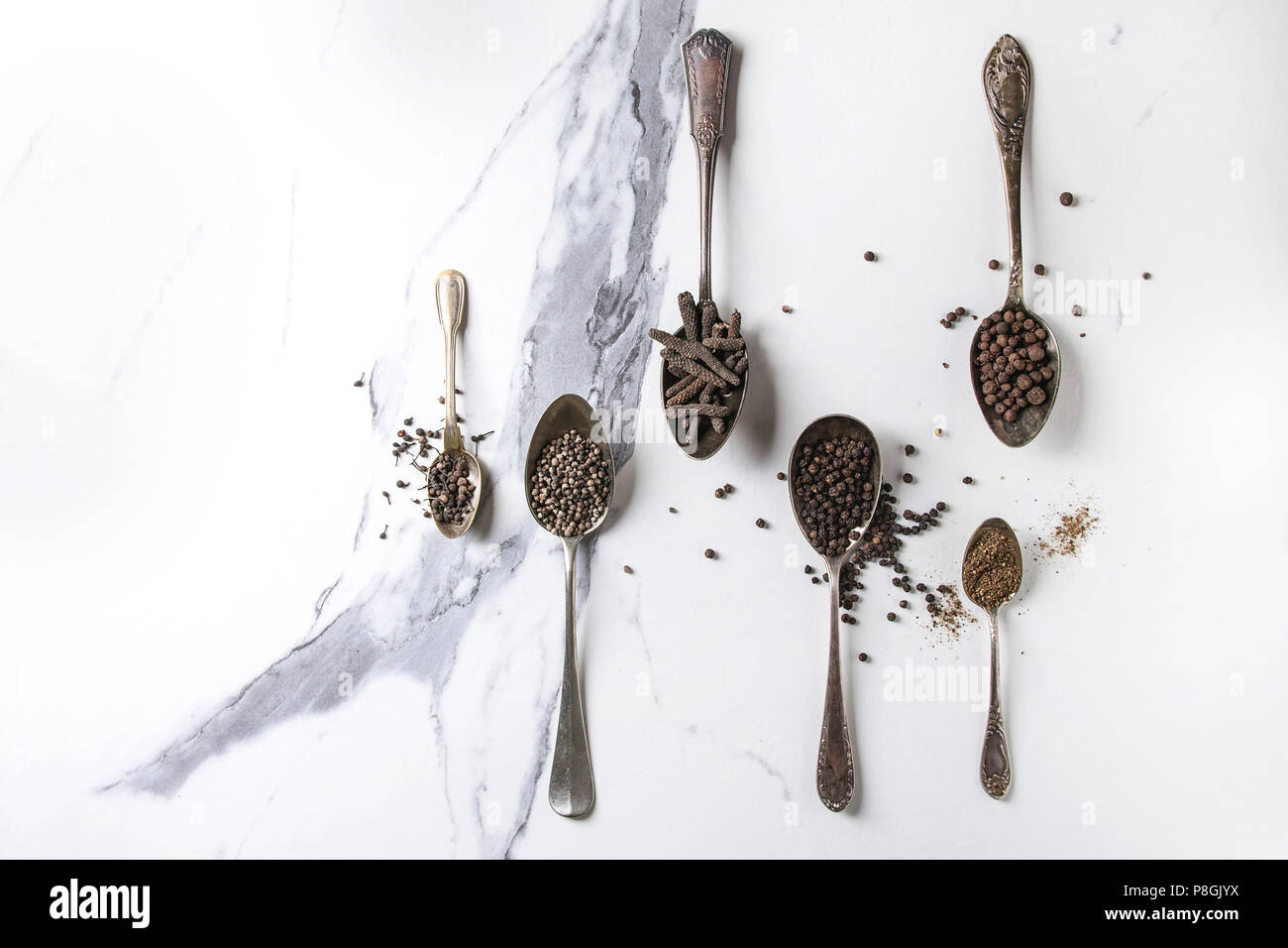 Variety of different black peppers allspice, pimento, long pepper ...