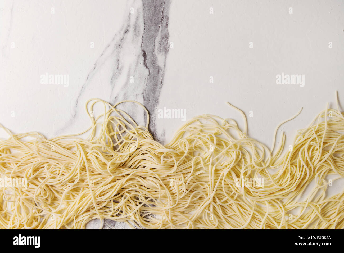 Homemade italian uncooked pasta spaghetti with semolina flour over ...