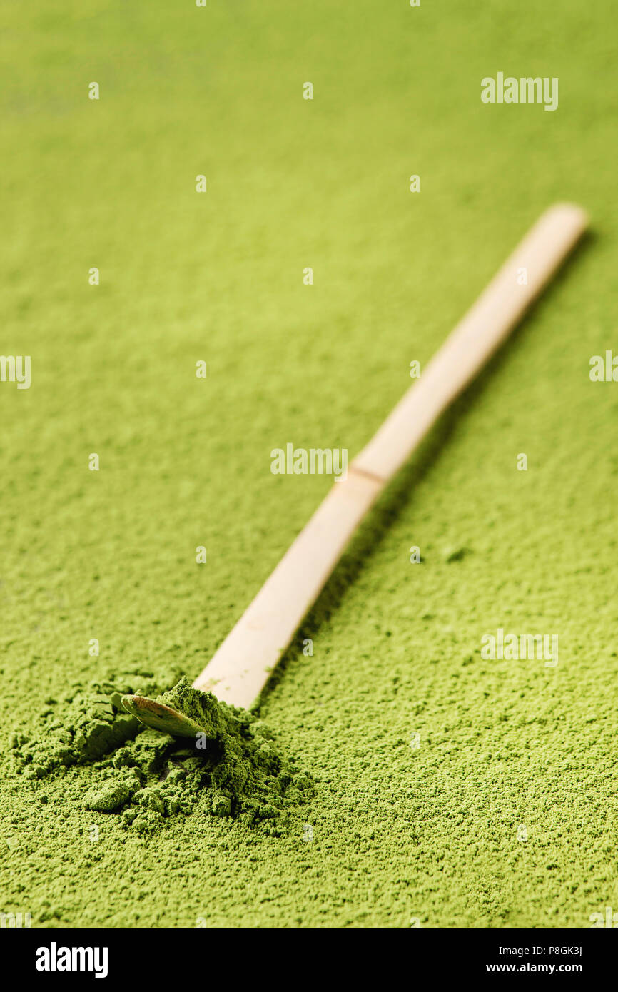 Green tea matcha powder in traditional bamboo spoon over powdering ...