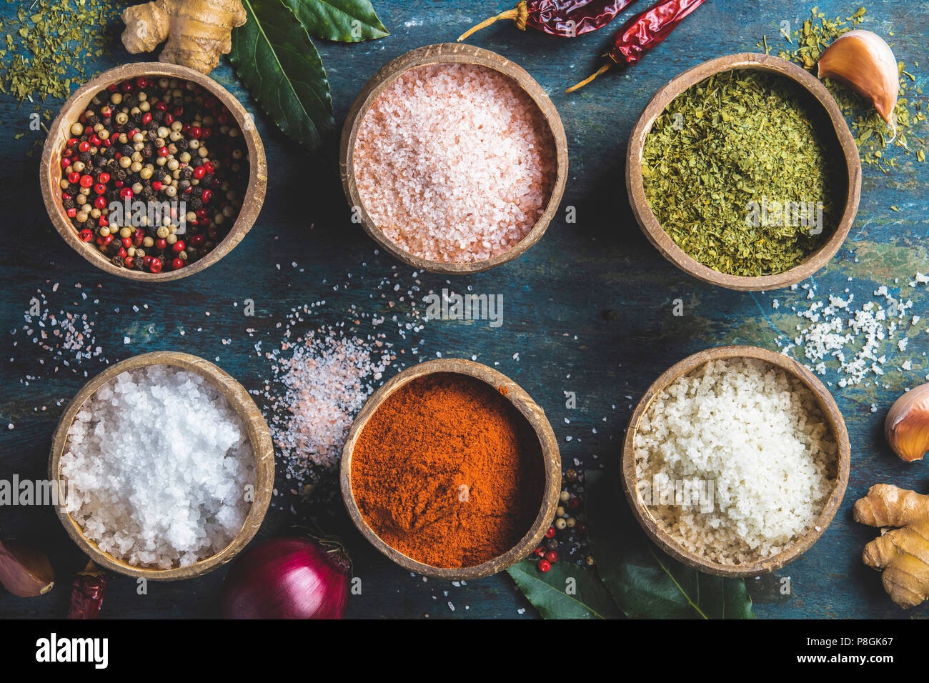 Set of spices on rustic blue background. Coconut shell bowls with ...