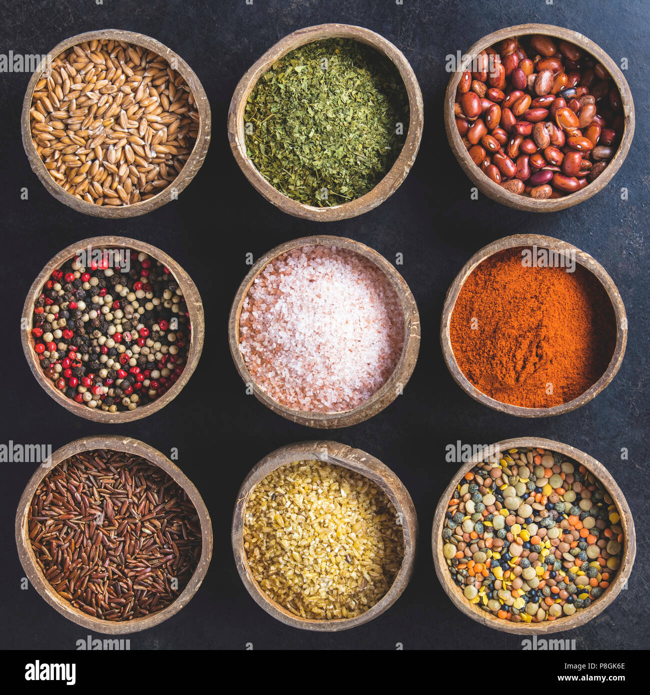 Set of spices on dark rustic background. Coconut shell bowls with ...