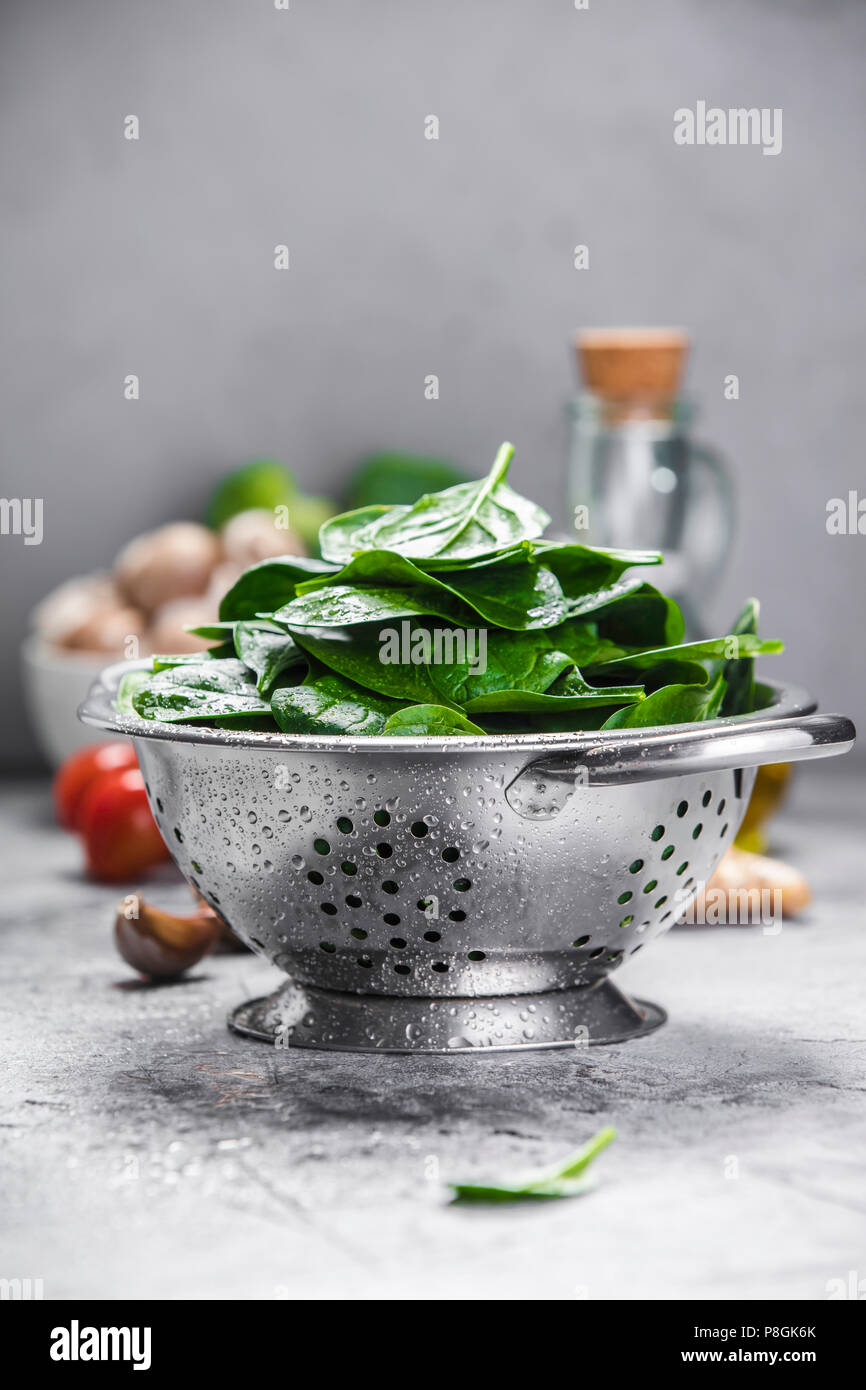 Spinach. Fresh organic spinach leaves in metal colander and healthy ...