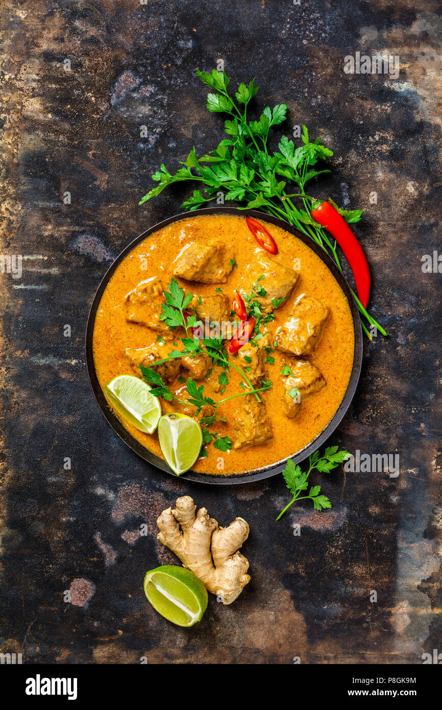 Traditional curry and ingredients on dark background. Curry, lime ...