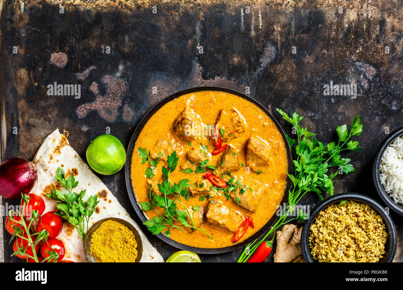 Traditional curry and ingredients on dark background. Curry, lime ...