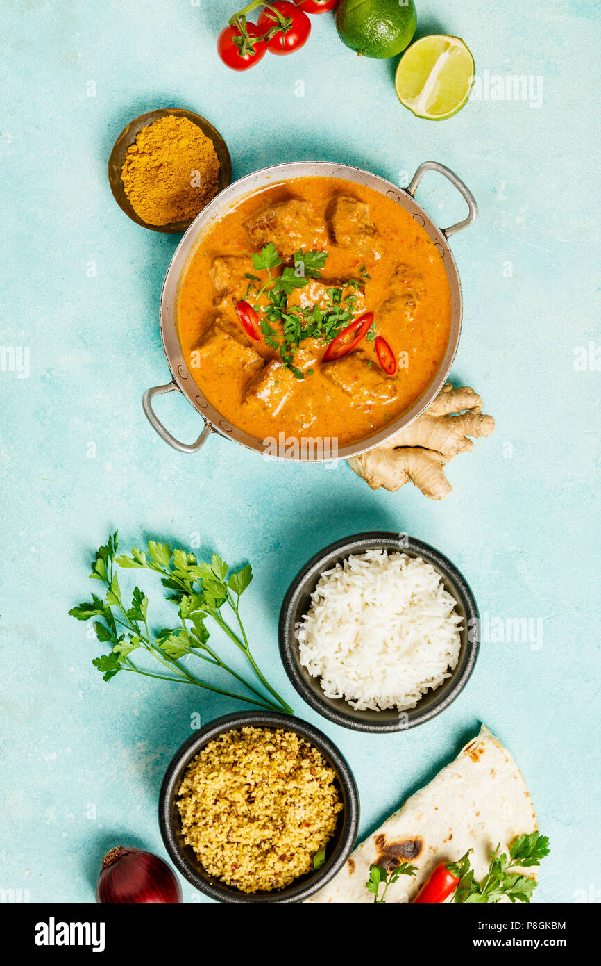 Traditional curry and ingredients on blue background. Curry, lime ...