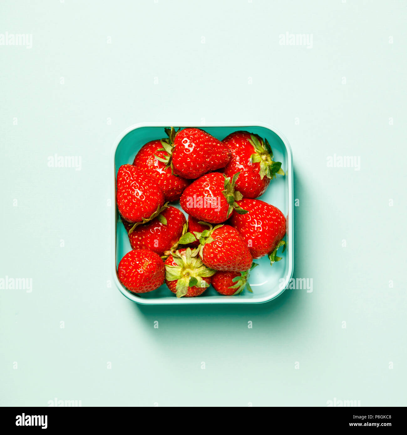 Container with fresh strawberry on pastel blue background. Flat lay ...