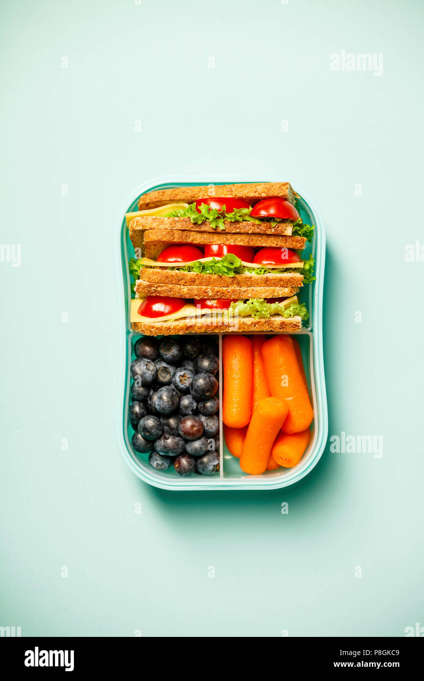 Creative flat lay with healthy lunch in blue container on pastel blue ...